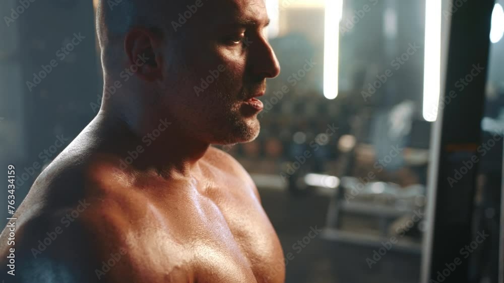 A determined male bodybuilder with impressive biceps diligently works ...