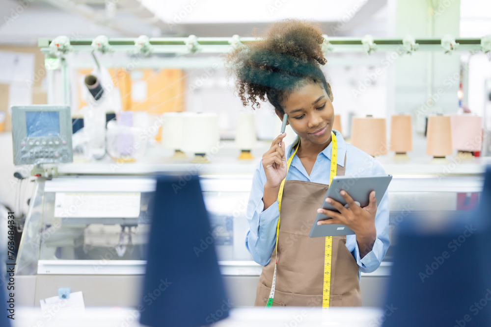 Seamstress thinking concept with tablet, working on designing a dress ...