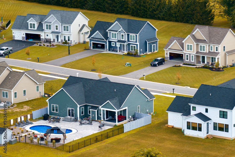 Upscale suburban homes with large backyards and green grassy lawns in ...