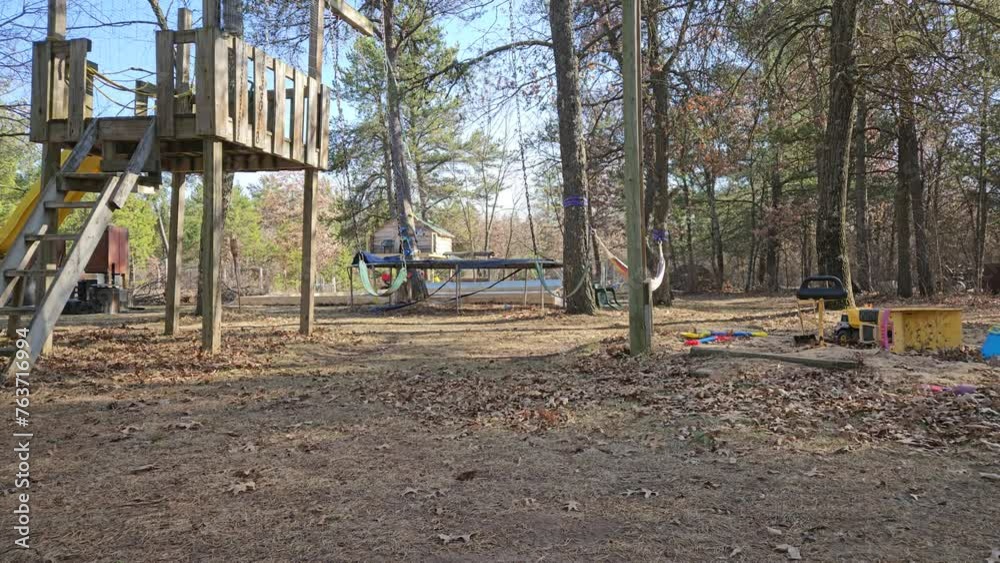 Empty old swing set sway in windy sunny day next to sandbox and slide ...
