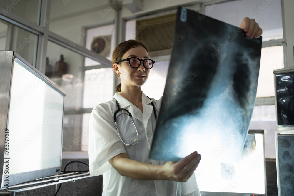 Female doctor checking anatomy and physiology x-ray film of patient in ...