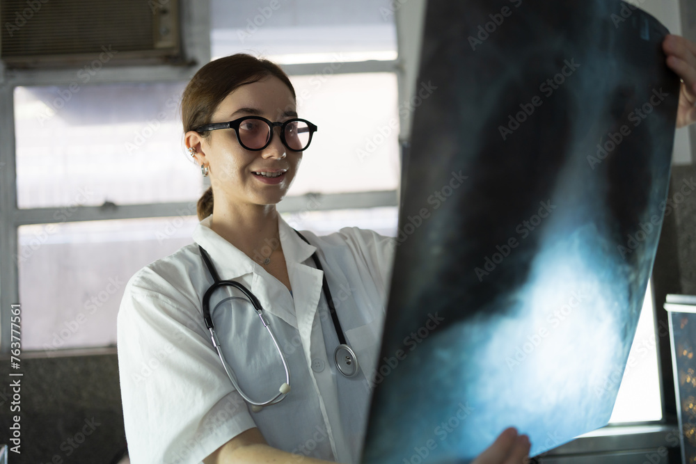 Female doctor checking anatomy and physiology x-ray film of patient in ...