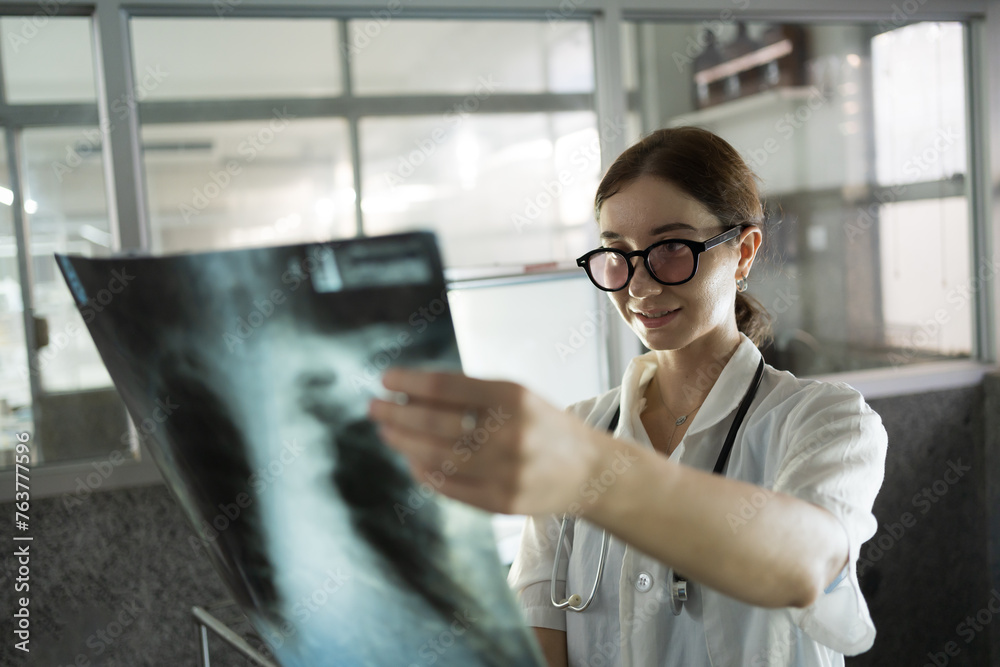 Female doctor checking anatomy and physiology x-ray film of patient in ...