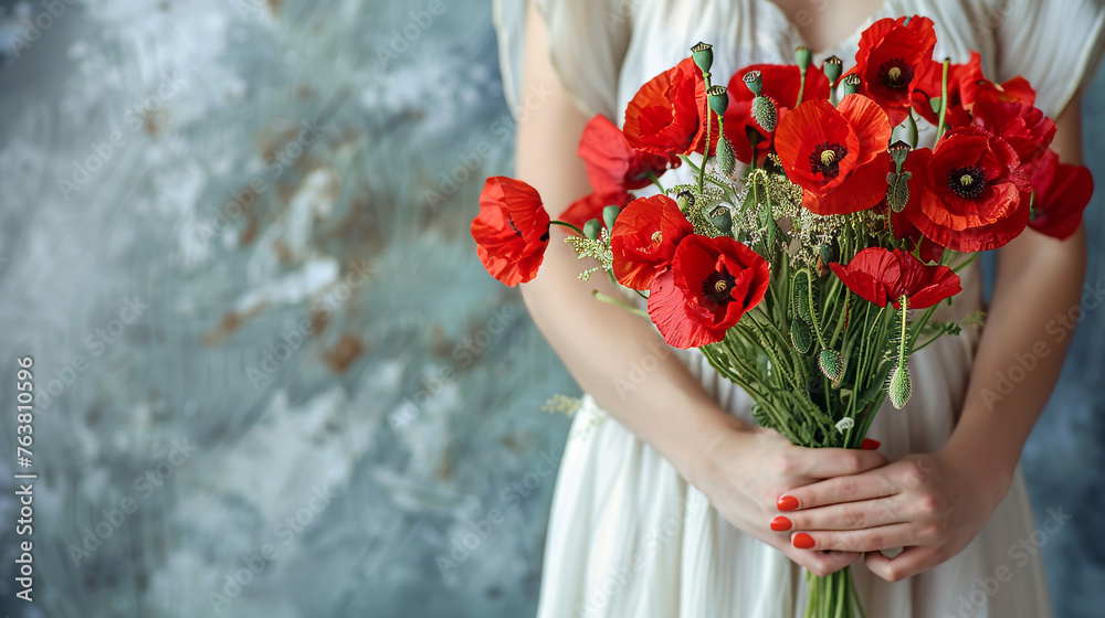 Beautiful woman hands holding a bouquet of red poppy flowers background ...