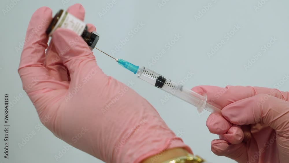 Doctor wearing pink gloves holding syringe, preparing for medical ...