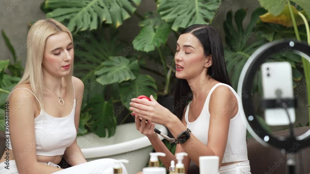 Two beautiful content creator making natural beauty and cosmetic tutorial on green plant leave ...
