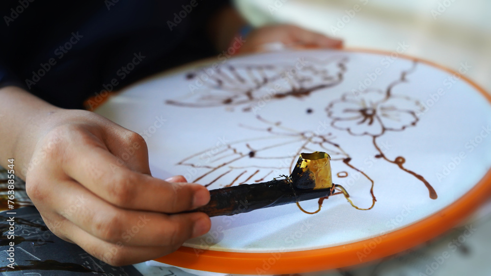 Batik making process, a handmade traditional art from Indonesia. Person ...