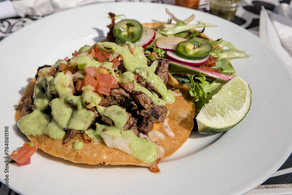 carne asada vampiro tostada and fish taco on a plate at a mexican ...