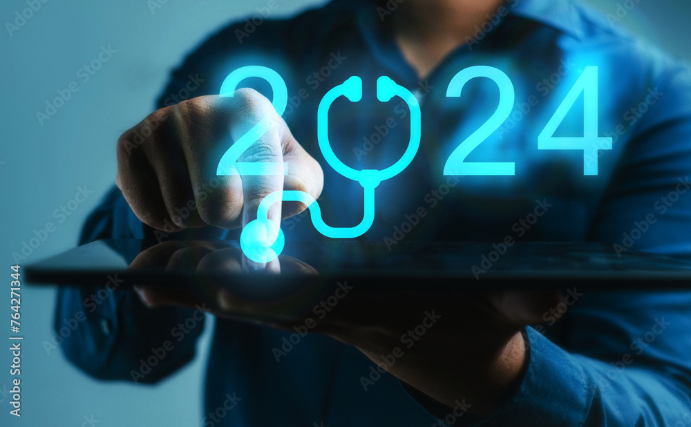 A man is pointing at a tablet with the Year 2024 on it. The image is a ...