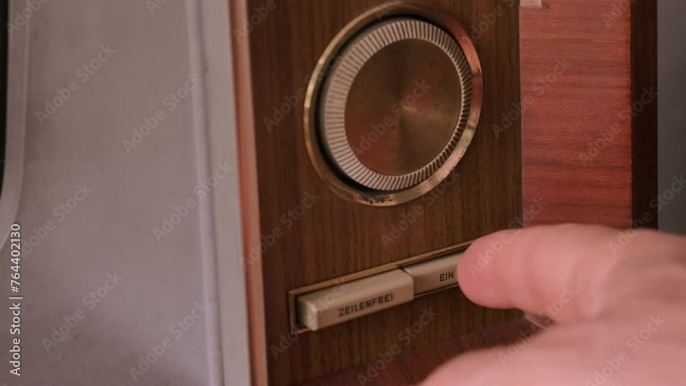 male Hand turns on TV power button, adjusts volume control old retro ...