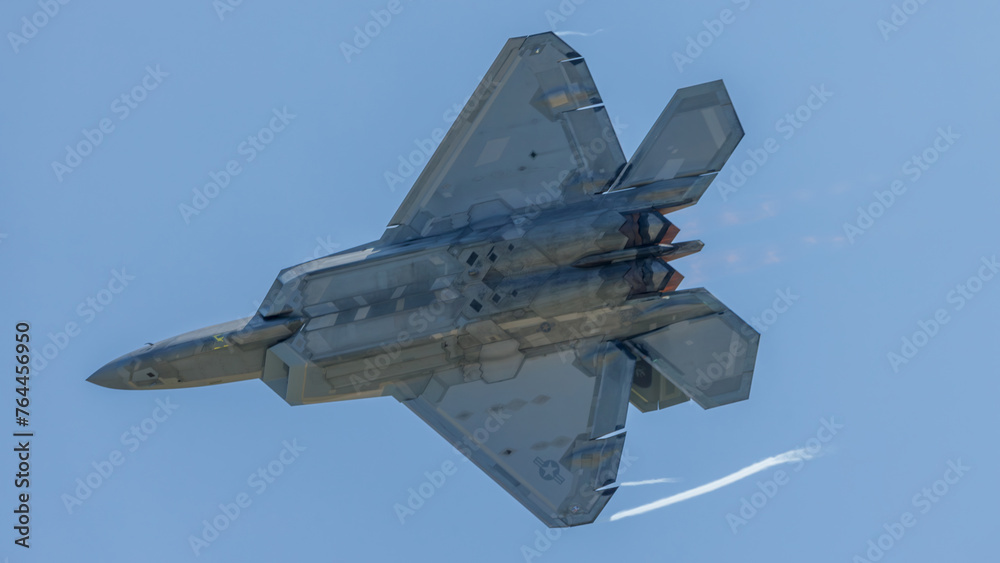 F-22 fighter underside in right bank with contrail coming from wingtips ...