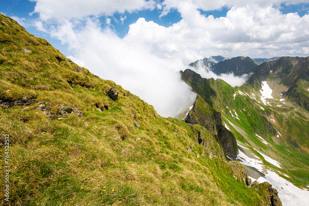landscape of transylvania alps in summer. spots of snow among grass on ...