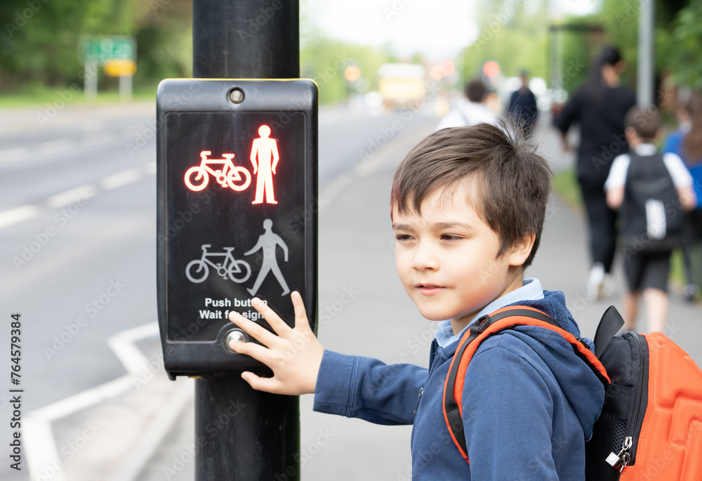 School kid pressing a button at traffic lights on pedestrian crossing ...