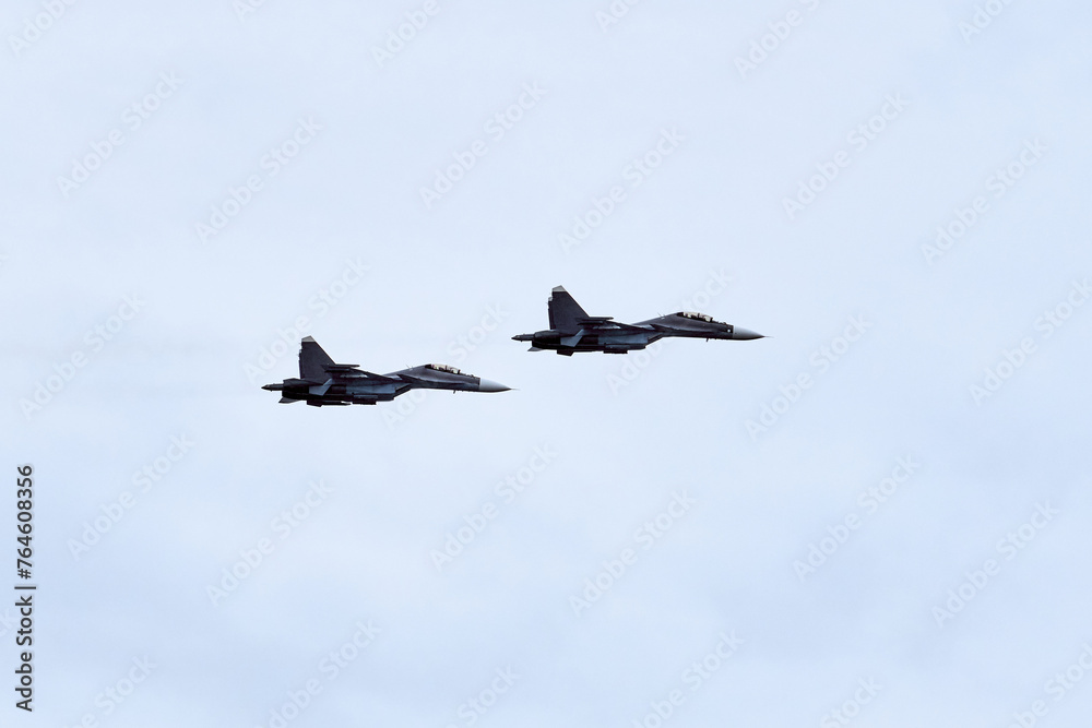 Two Russian military fighter planes armed with missiles flies in blue ...