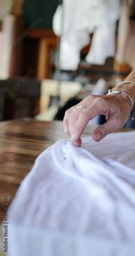 Vertical video a close-up of a female tailor hands touching the surface ...