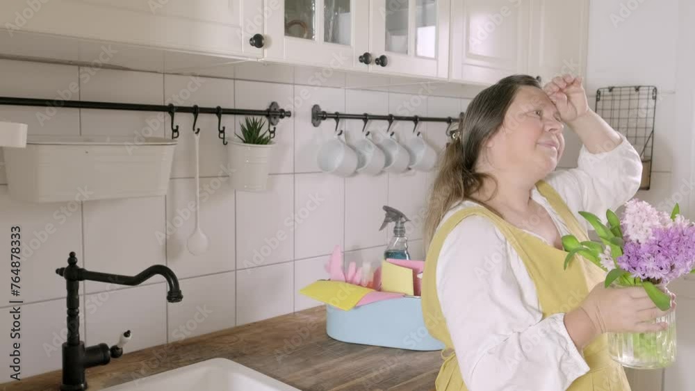 tired woman in apron wipes sweat off forehead, indicating busy kitchen ...
