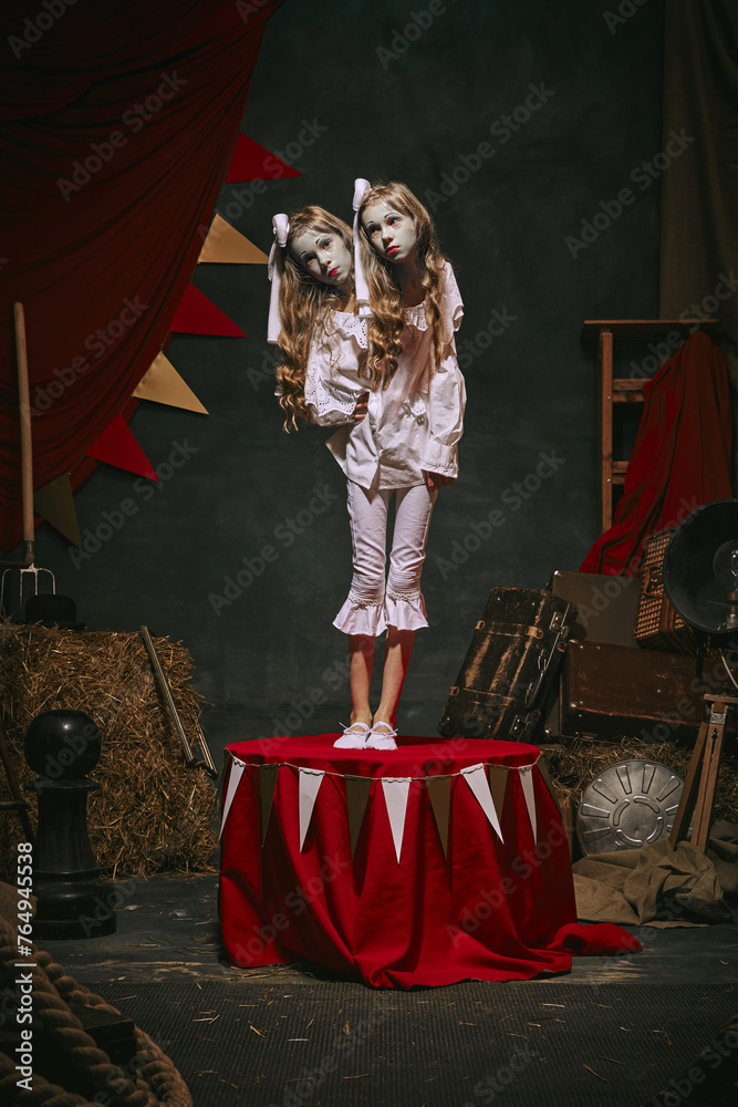 Siamese twin girls in white vintage costumes with makeup standing on ...