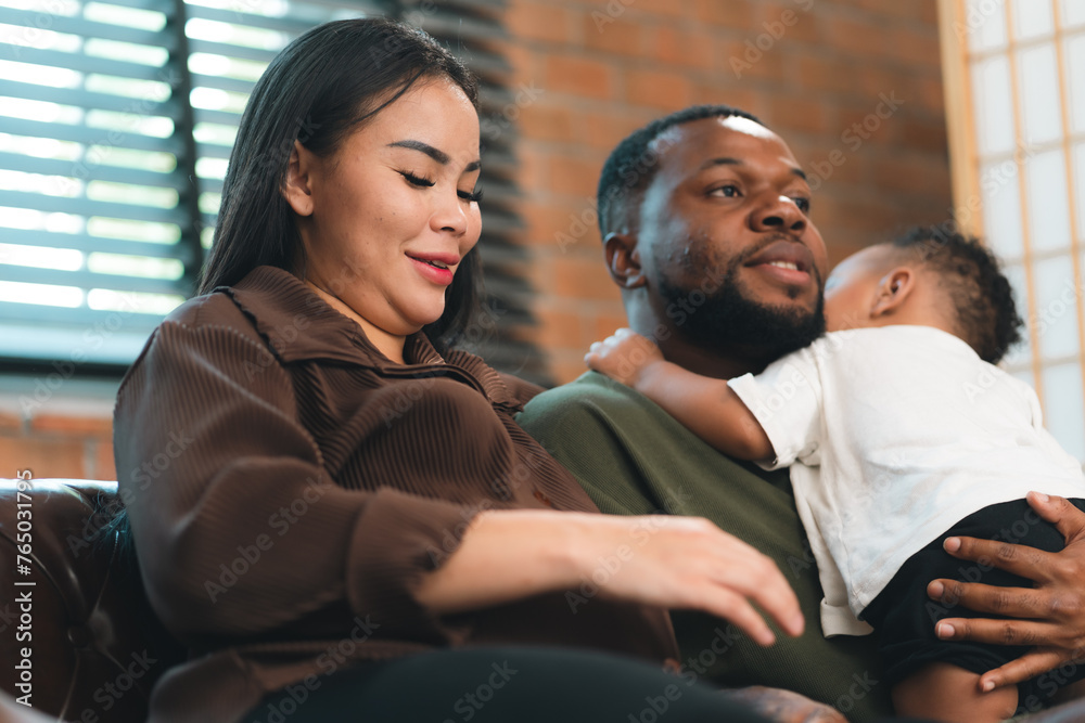 Smiling African-American father shares fun and love with his cheerful ...
