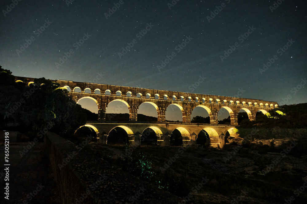 illuminated ancient Roman aqueduct Pont du Gard near Languedoc, France ...