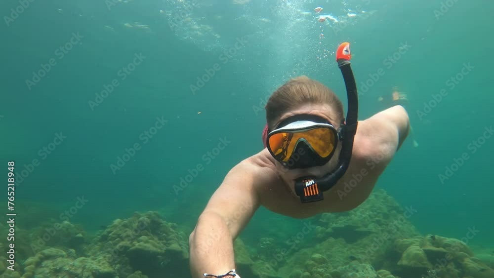 Shirtless man snorkeling underwater wearing mask and goggles for ...