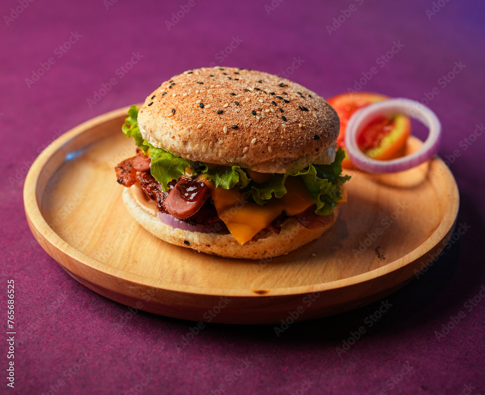Burger served on a wooden plate with lettuce, onion, and tomato. social ...