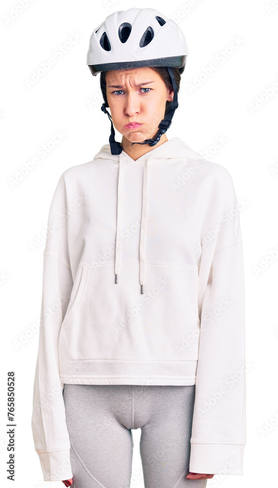 Beautiful brunette young woman wearing bike helmet and sporty clothes ...