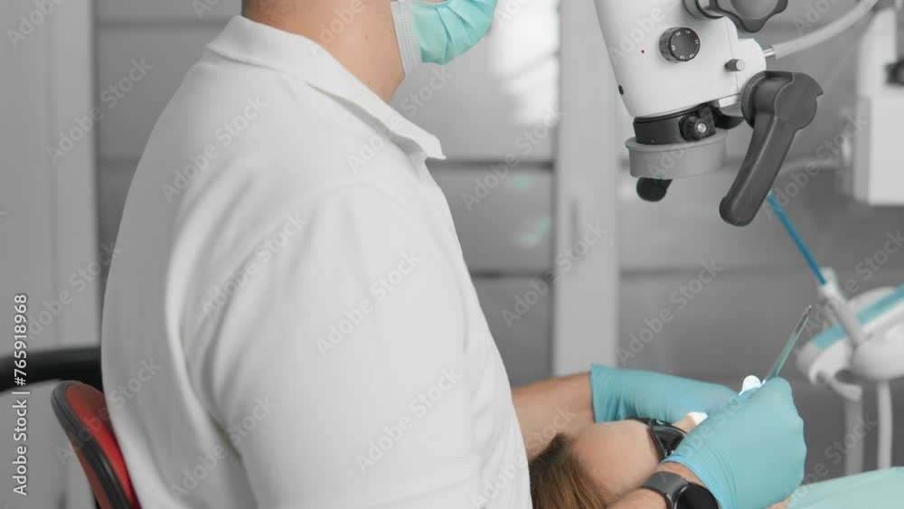 During periodontal surgery, the dentist uses a microscope to precisely ...