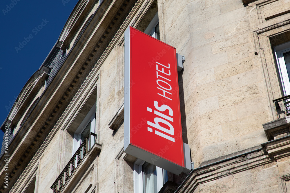 Ibis hotel brand text and sign red logo on facade hostel wall building ...