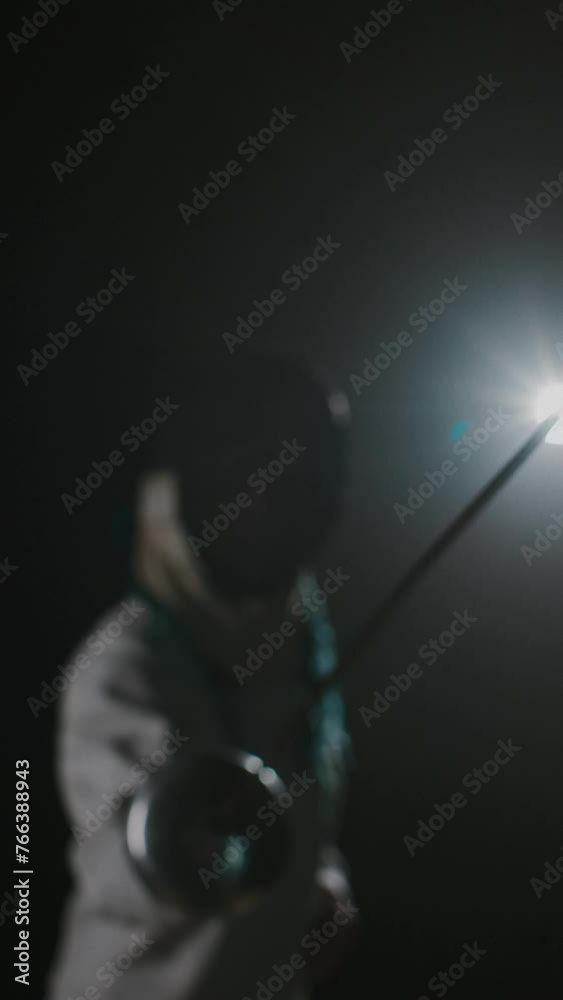 Vertical footage of foil fencer pointing fencing rapier while standing ...