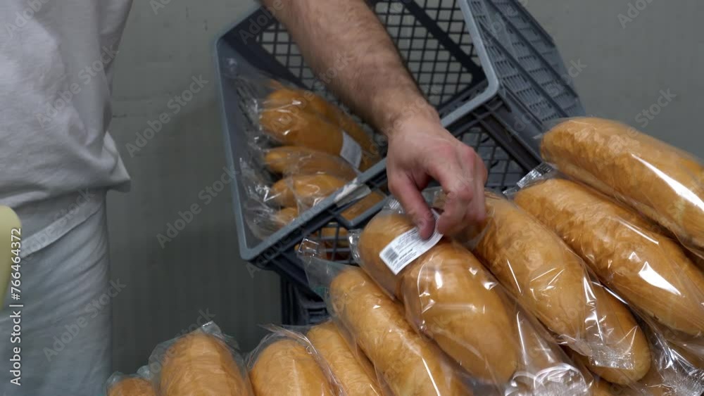 Bakery Worker Applying Labels to Loaves of Bread in Transparent ...