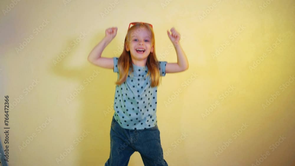 Excited little girl raising arms and jumping high up. Happy child with ...