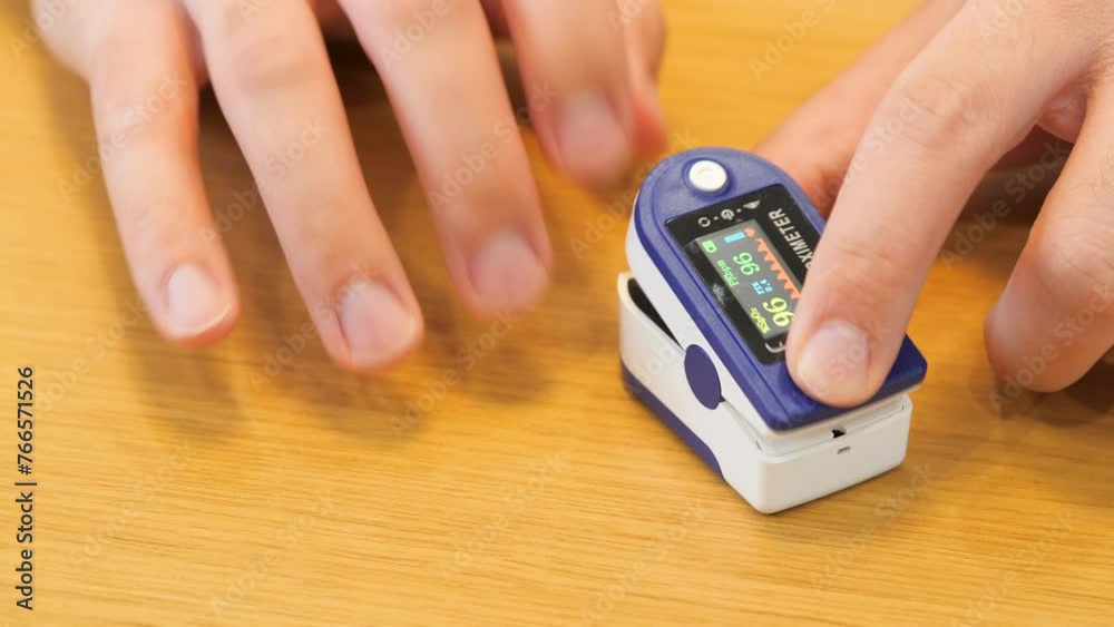 Human hand pulse oximeter used to measure pulse rate and oxygen levels ...