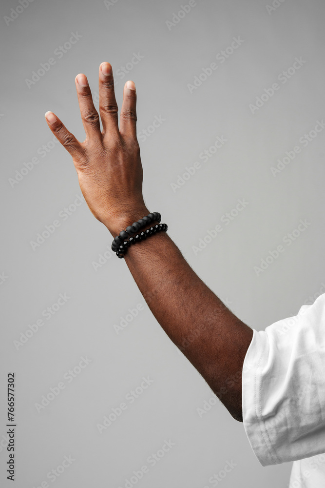 Human Hand Gesturing Four Fingers Up Against a Neutral Grey Background ...