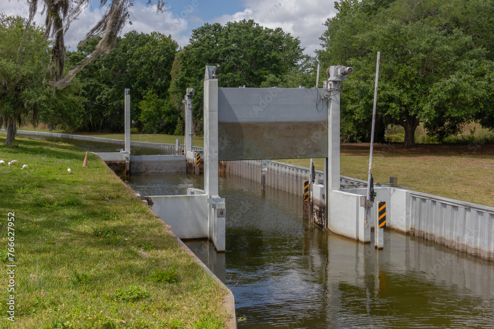 Man-made canal with locks for barges and narrow boats, grassy area and ...