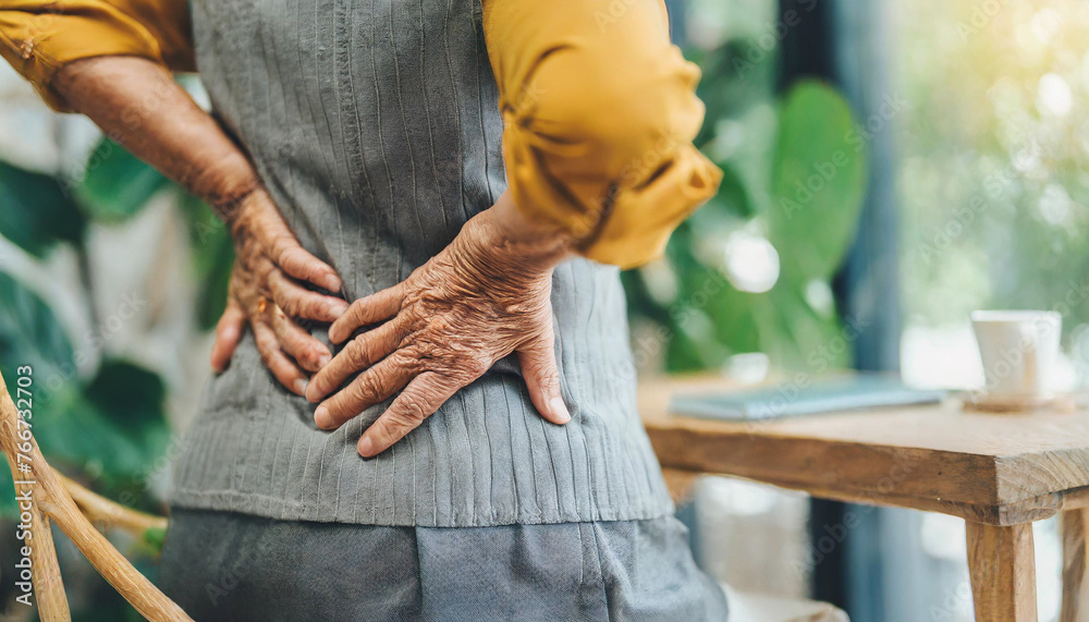 elderly woman's hands clutching her aching back, symbolizing pain and ...