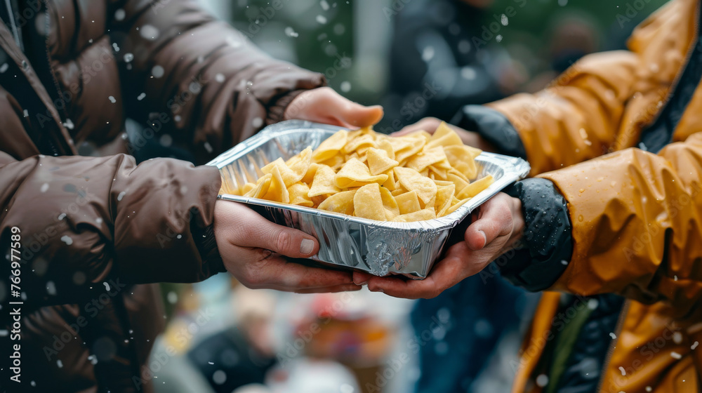 Volunteer hands giving to poor homeless person hot food. Food for ...