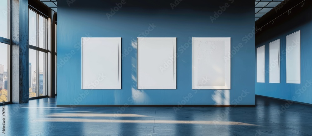 In an exhibition hall, four white vertical posters are displayed on a ...