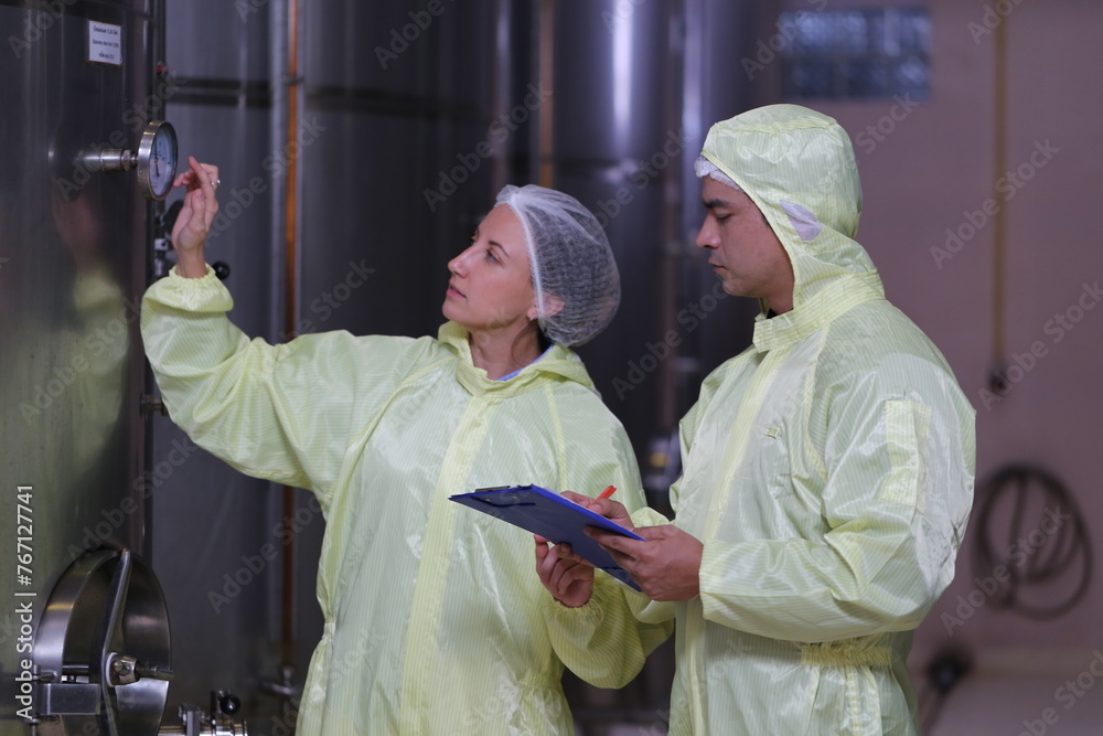 Winemaker woman and business owner wearing a sterile suit working and ...