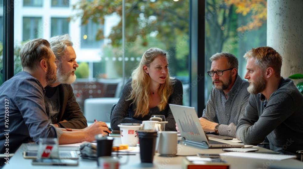 Team collaboratively working around a modern office table. Capturing ...