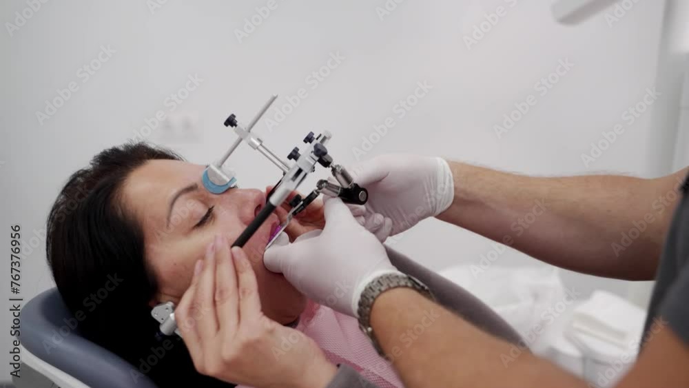 Vidéo Stock Orthodontist installing dental facebow on woman face in ...