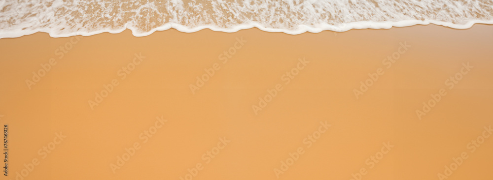 Ultrawide shoreline overhead shot showing a shallow wave of water and ...