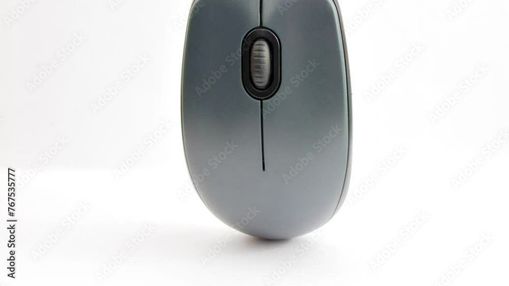 Gray computer mouse highlighted on a light surface, a symbol of ...