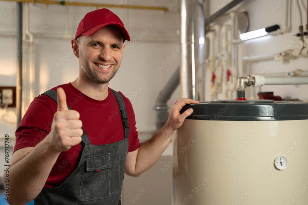 Foto de A skilled plumber wearing a red cap and overalls is carefully ...