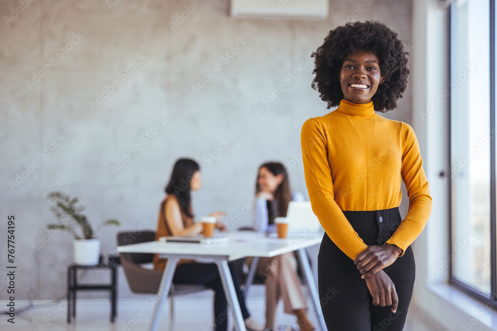 Beautiful young grinning professional Black woman in office, folded ...
