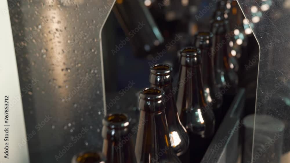 Technological line for bottling of beer in brewery. Empty brown bottles ...