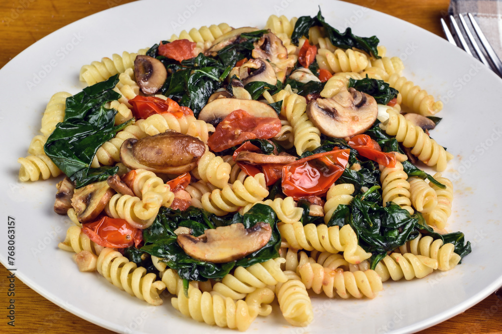 rotini served with spinach , mush rooms and tomatoes, Stock Photo ...