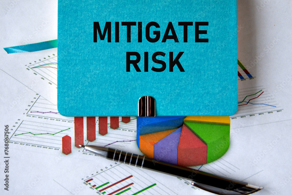 MITIGATE RISK - words on a green piece of paper on the background of a ...