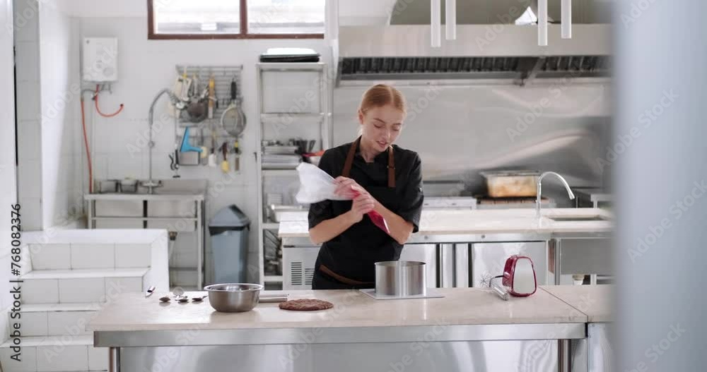 A long range shot of a professional kitchen in a pastry shop where a ...