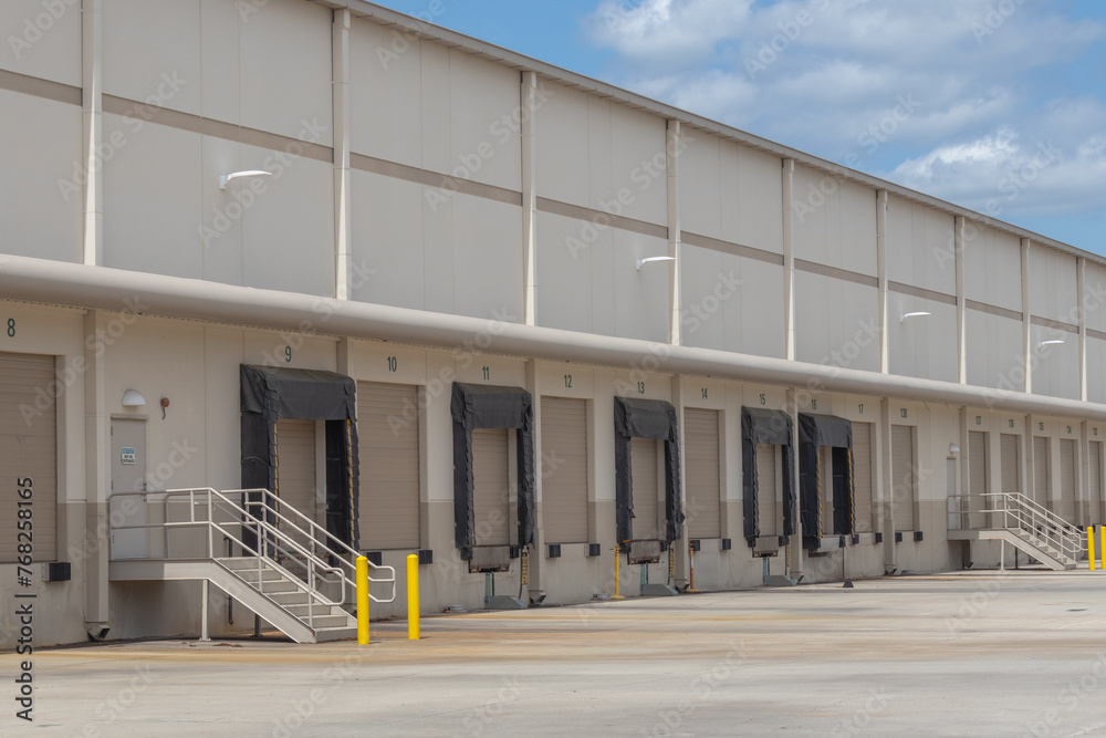 Side view of empty distribution warehouse with multiple bays for trucks ...