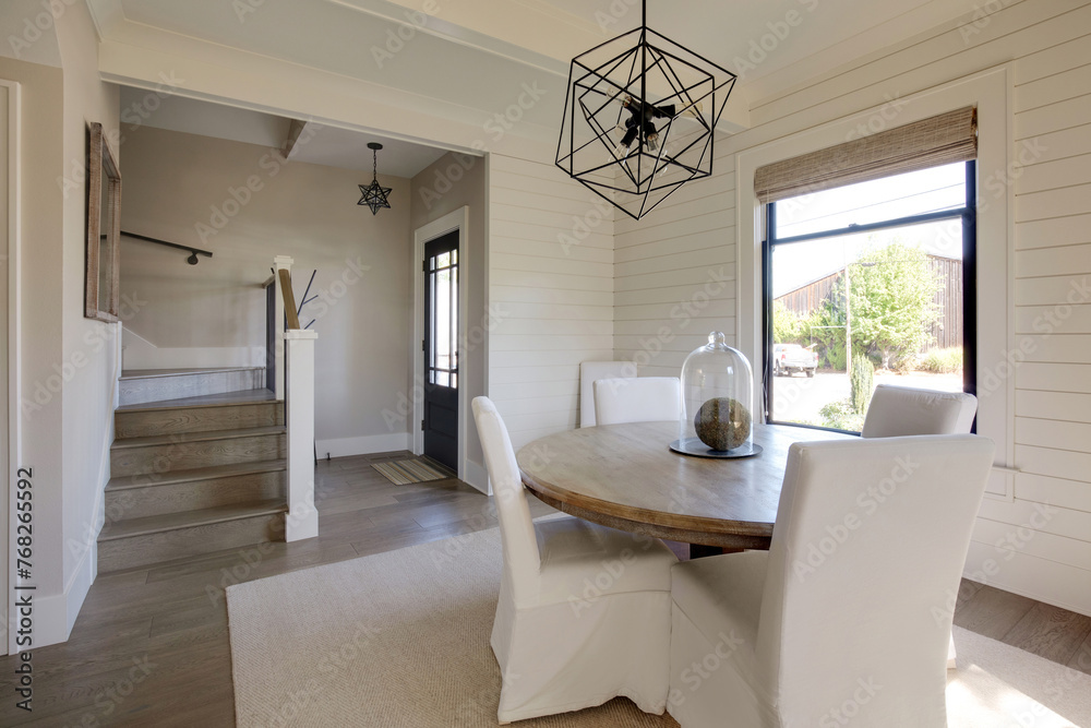 An elegant dining setup with white chairs around a stylish table, front ...